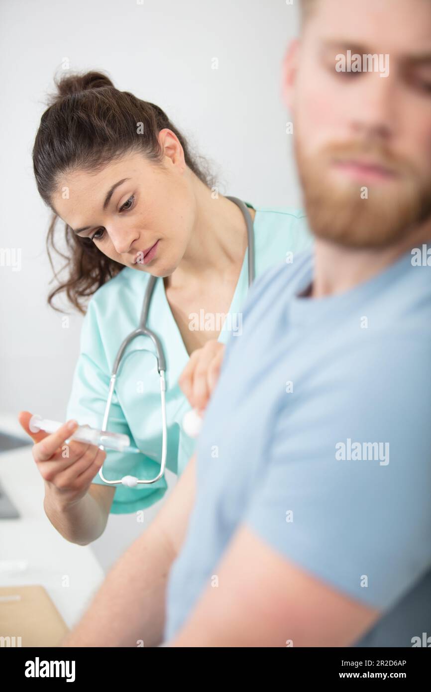 man looking away as nurse approaches with needle Stock Photo - Alamy
