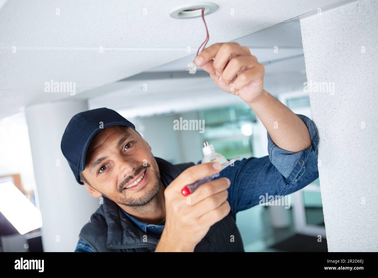 man standing on ladder changing a lightbulb Stock Photo - Alamy