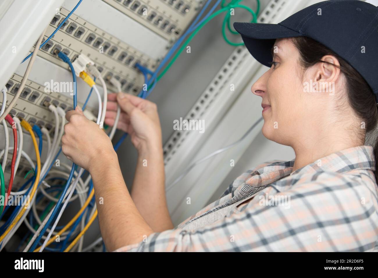 female technician connecting cables to server Stock Photo - Alamy