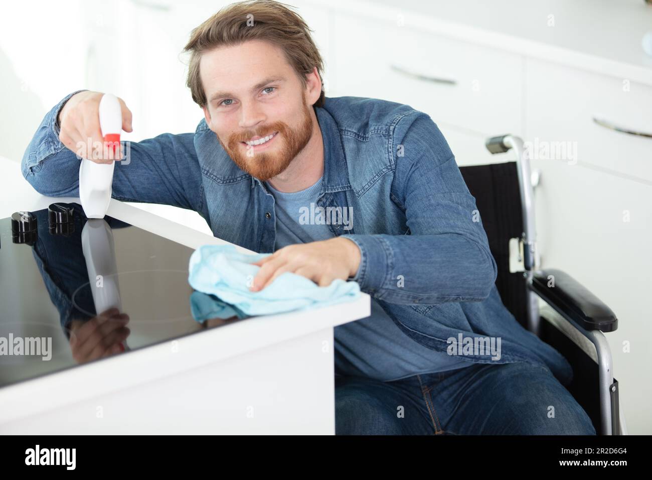 young disabled man on a wheelchair cleaning the kitchen Stock Photo - Alamy