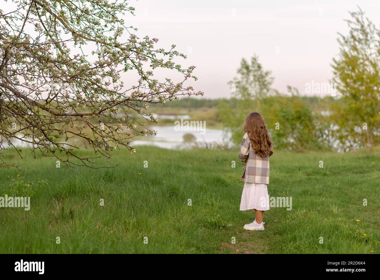A happy little girl walks in nature. The child is exploring nature ...