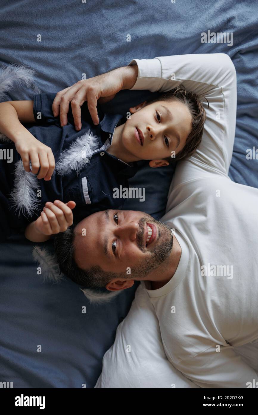 Father and son are lying on the bed Stock Photo - Alamy