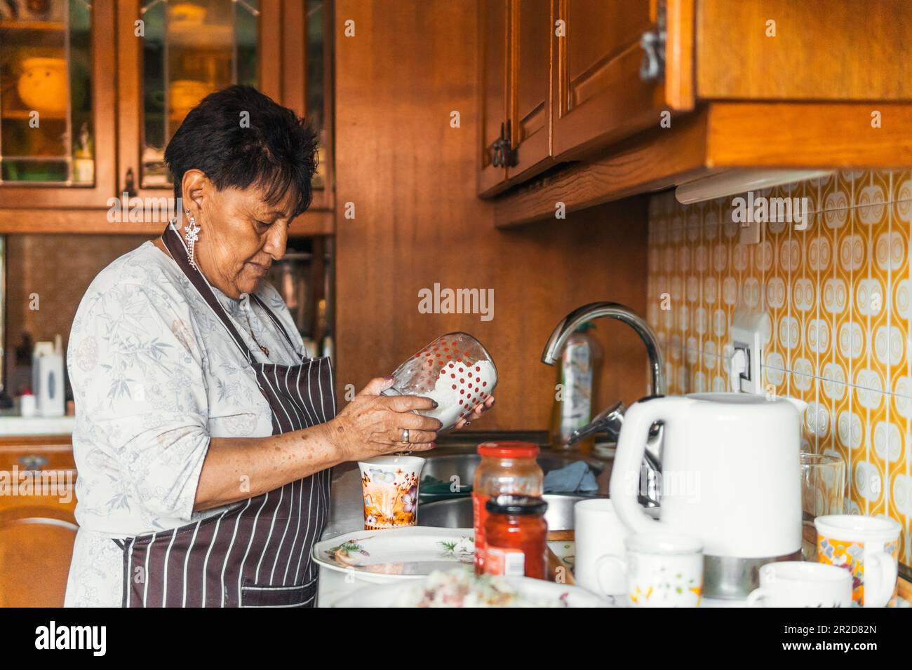 older latin American woman cooking at home Stock Photo - Alamy