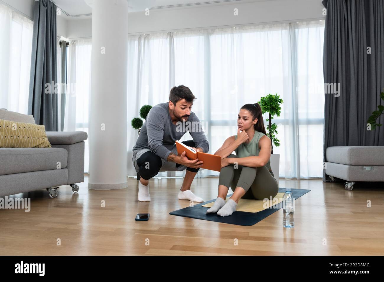 Woman with her personal fitness trainer. Couple exercising together ...