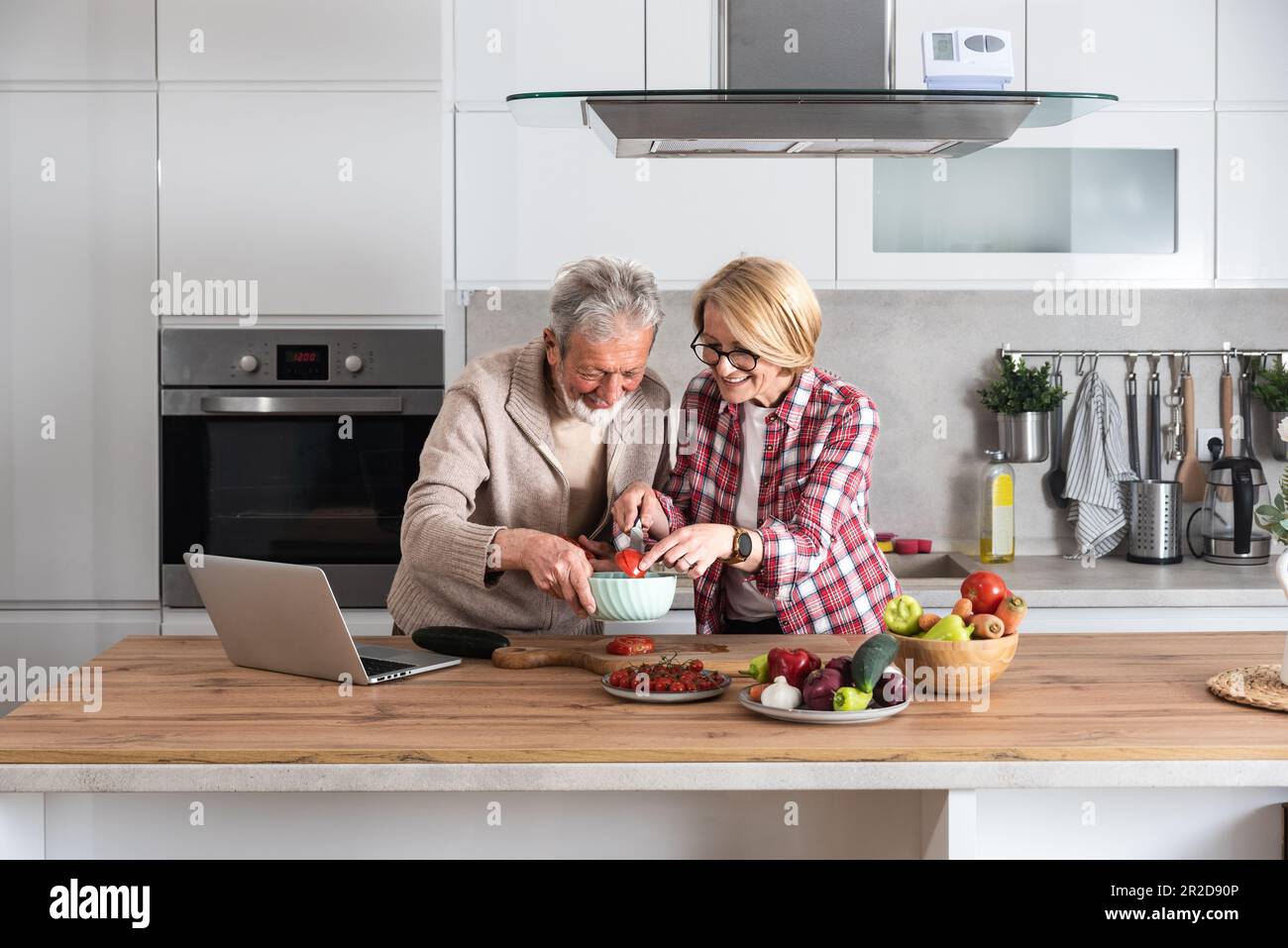 Senior couple cooking healthy food together from home organic ...
