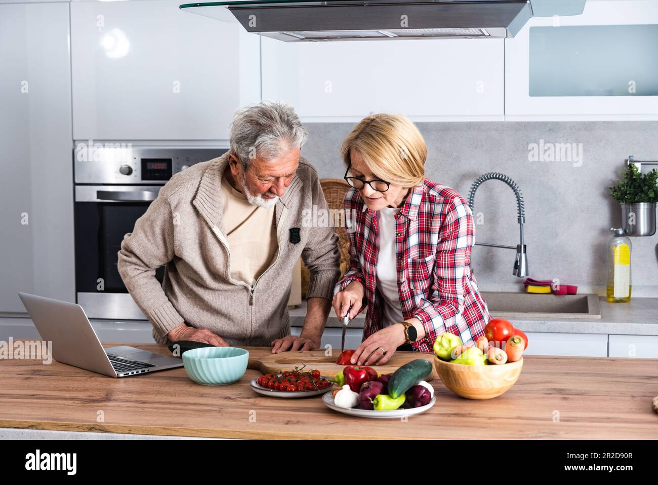 Senior couple cooking healthy food together from home organic ...