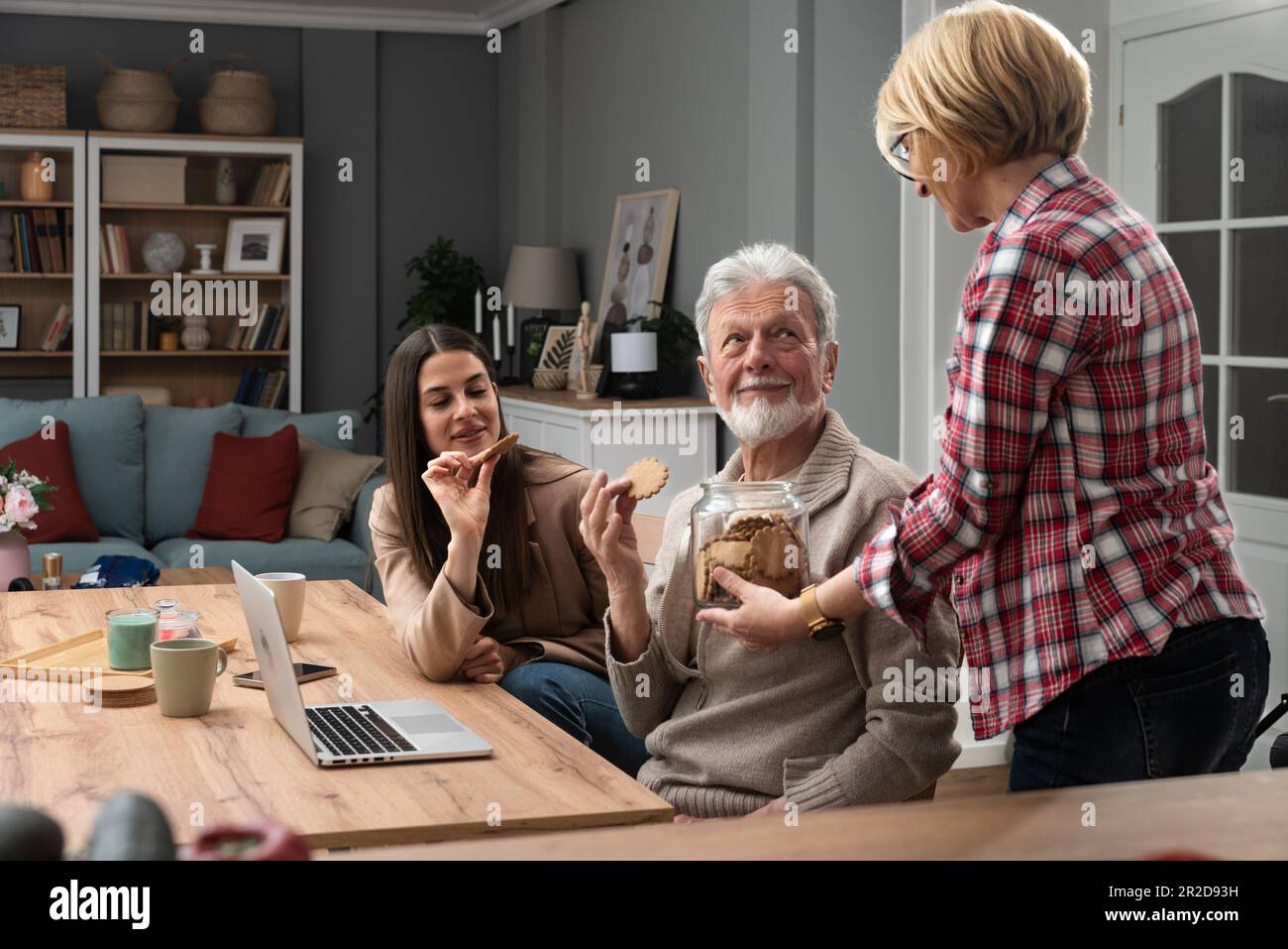 Playful family eating gingerbread cookies at home. Mom, father and ...