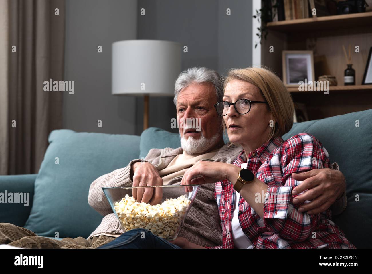 Mature married couple entertaining observing terrified TV program ...