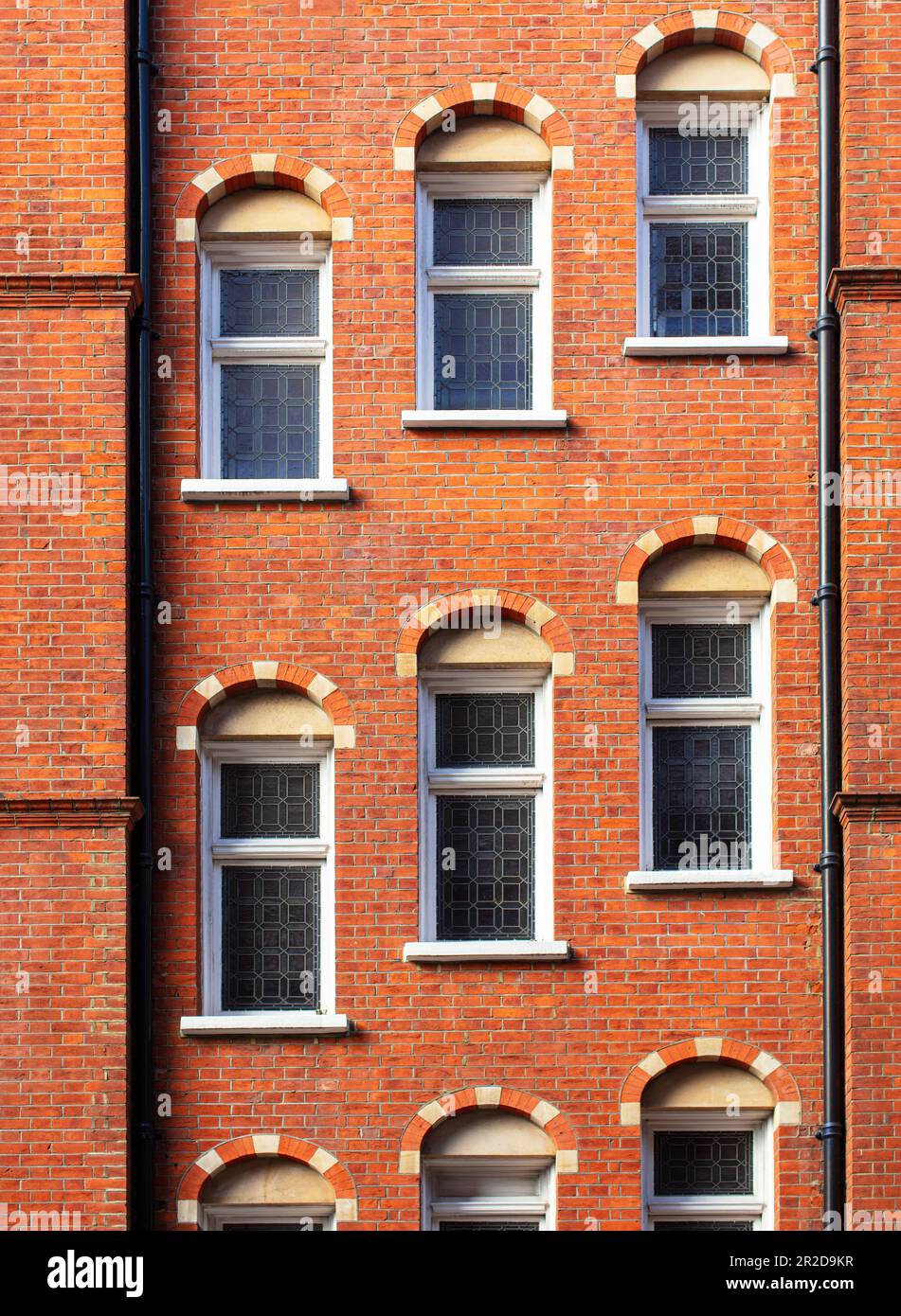 Diagonally arranged windows on red brick wall of mansion block in ...