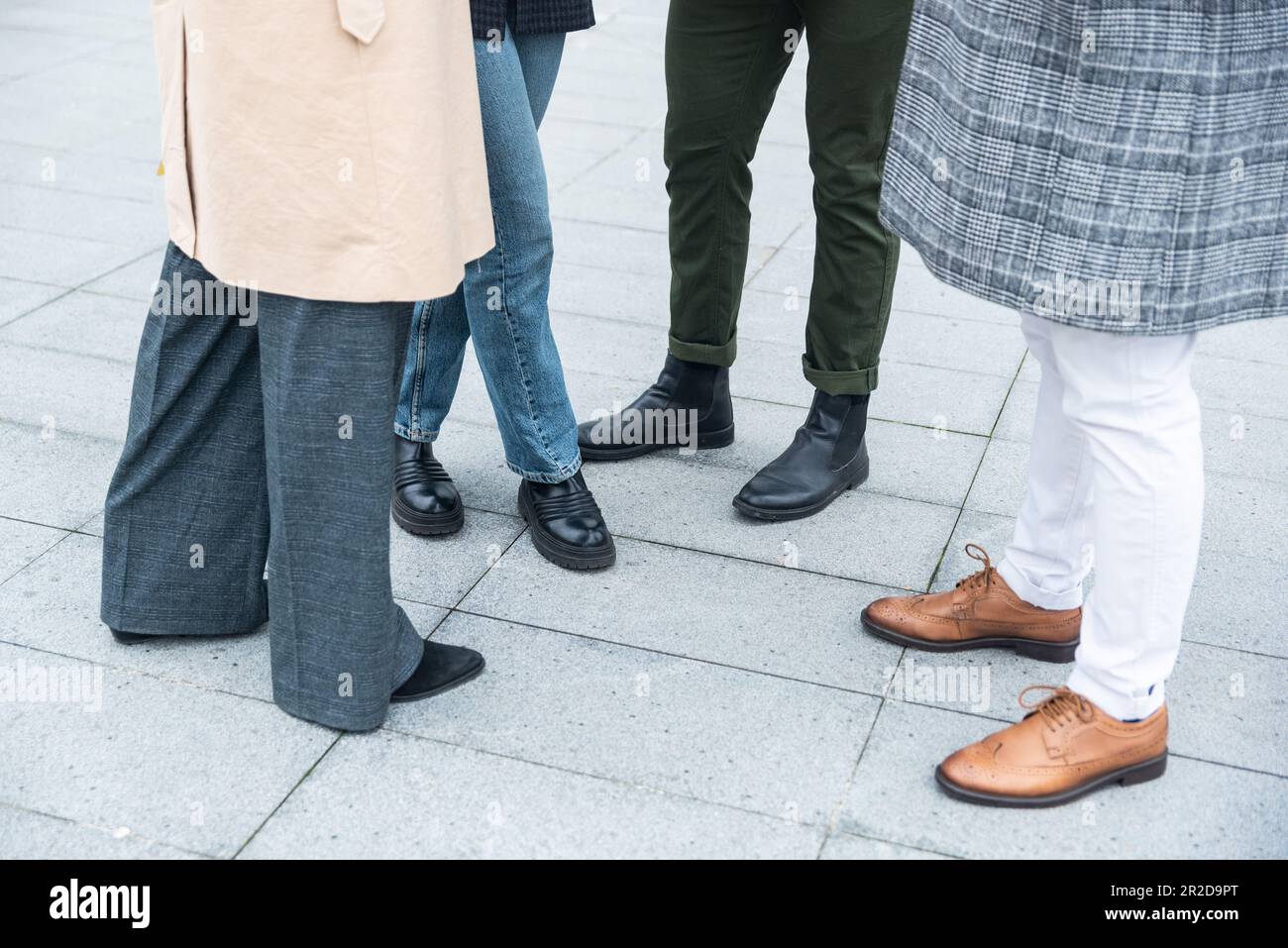 Unrecognizable businesspeople stand in a group in front of an office ...