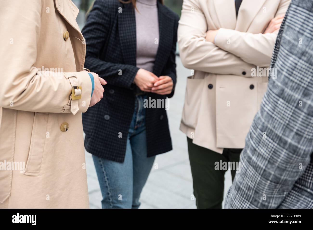 Unrecognizable businesspeople stand in a group in front of an office ...