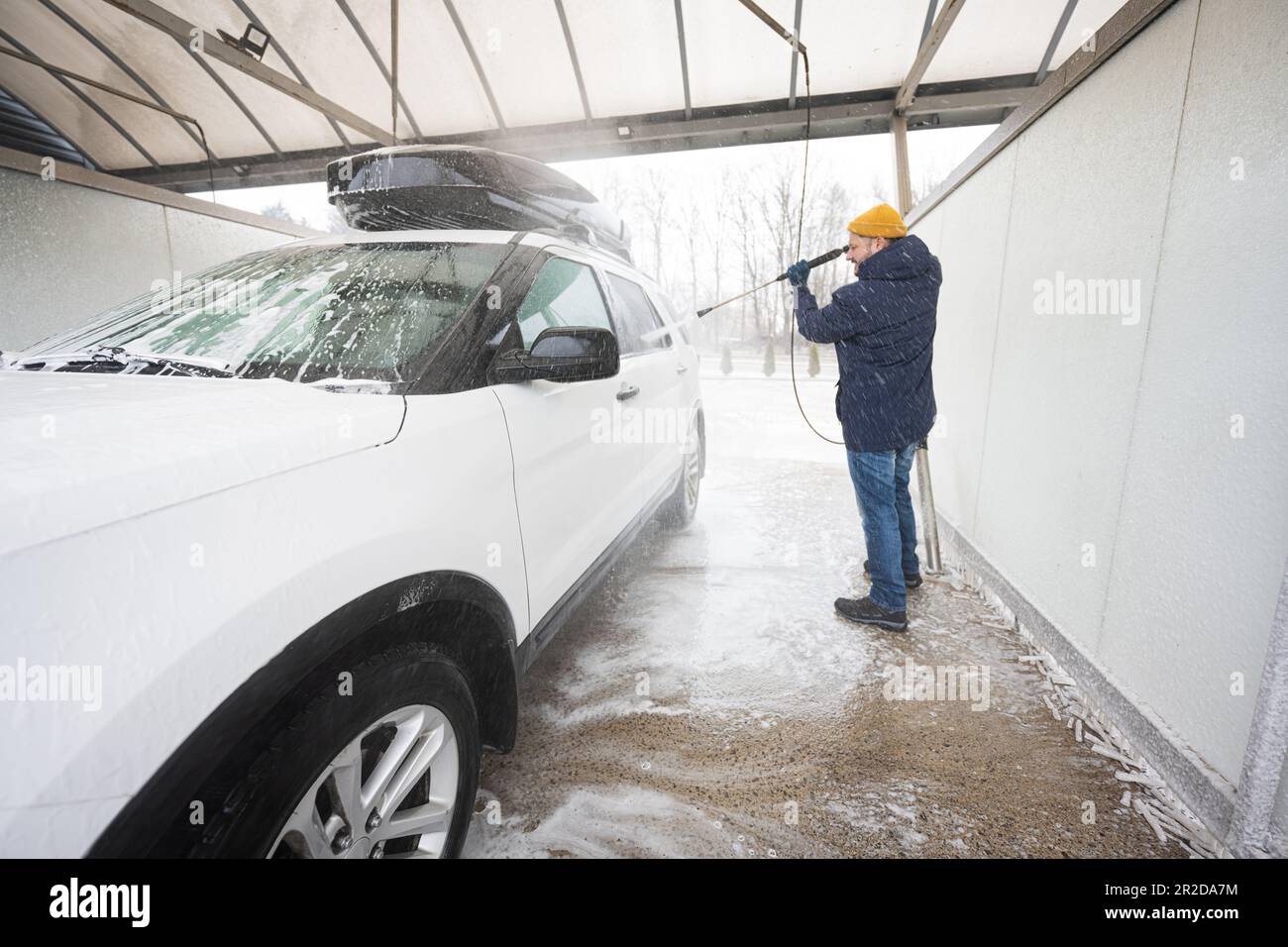 Man washing high pressure water american SUV car with roof rack at self ...