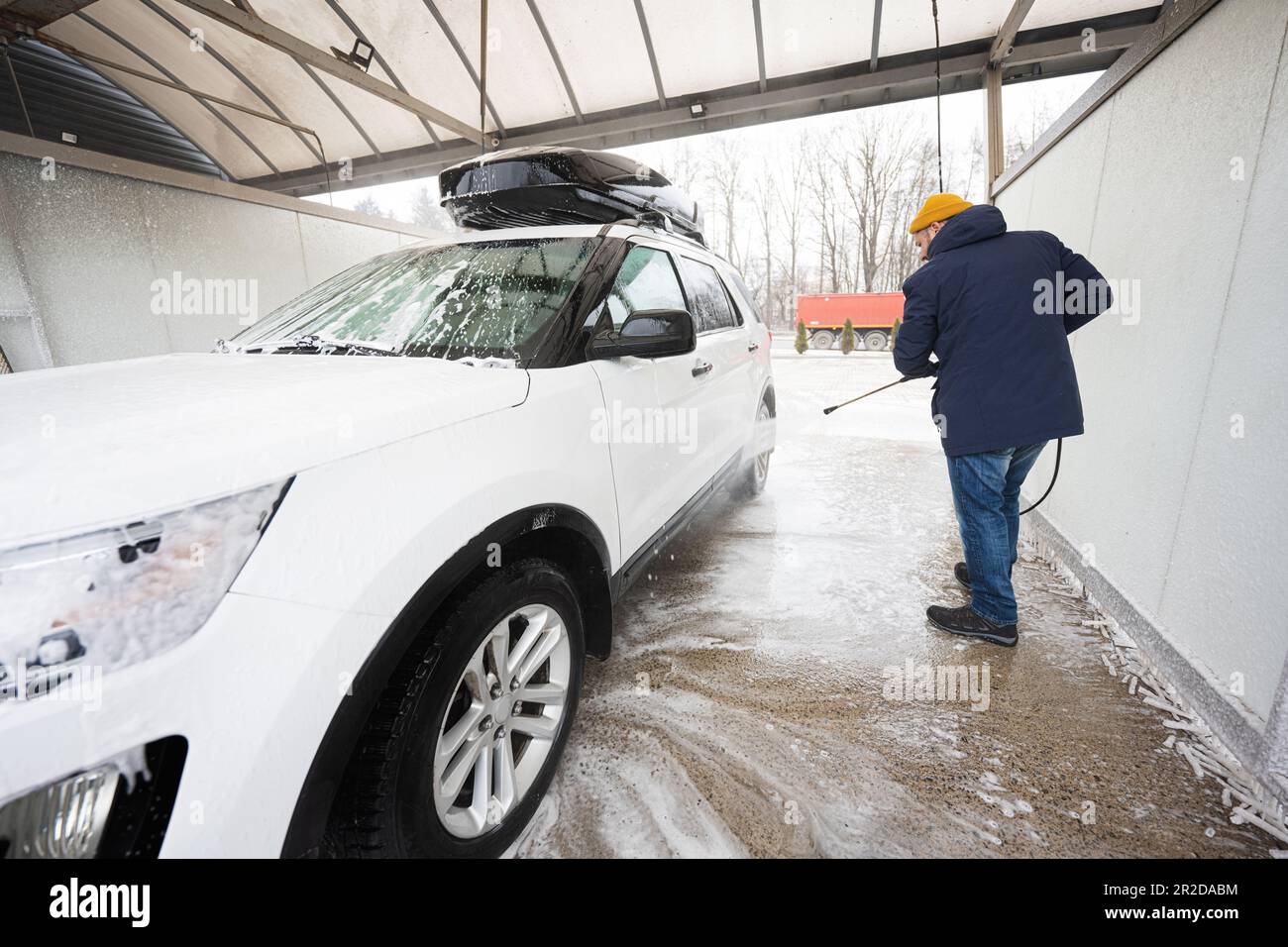 Man washing high pressure water american SUV car with roof rack at self ...