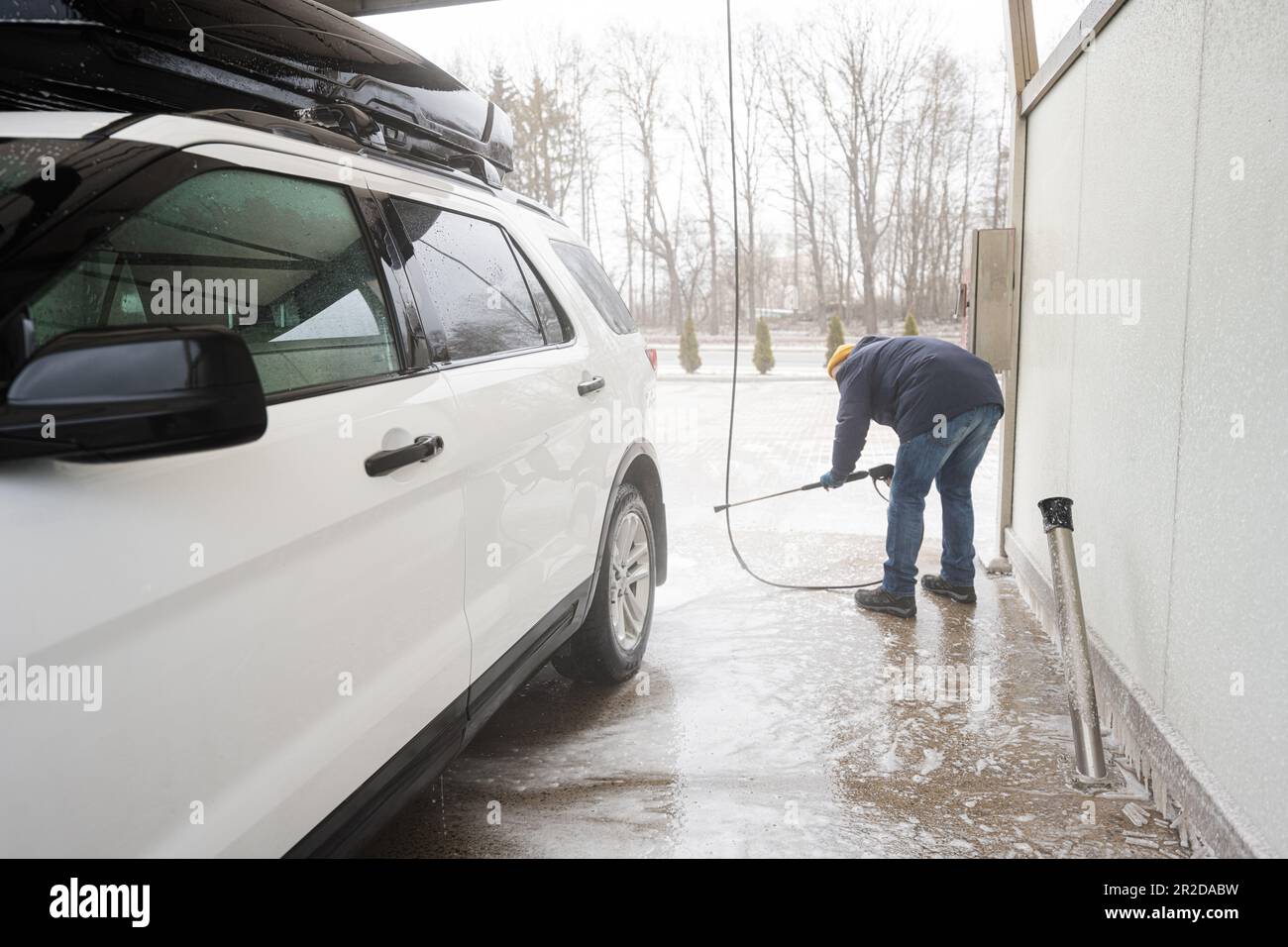 Man washing high pressure water american SUV car with roof rack at self ...