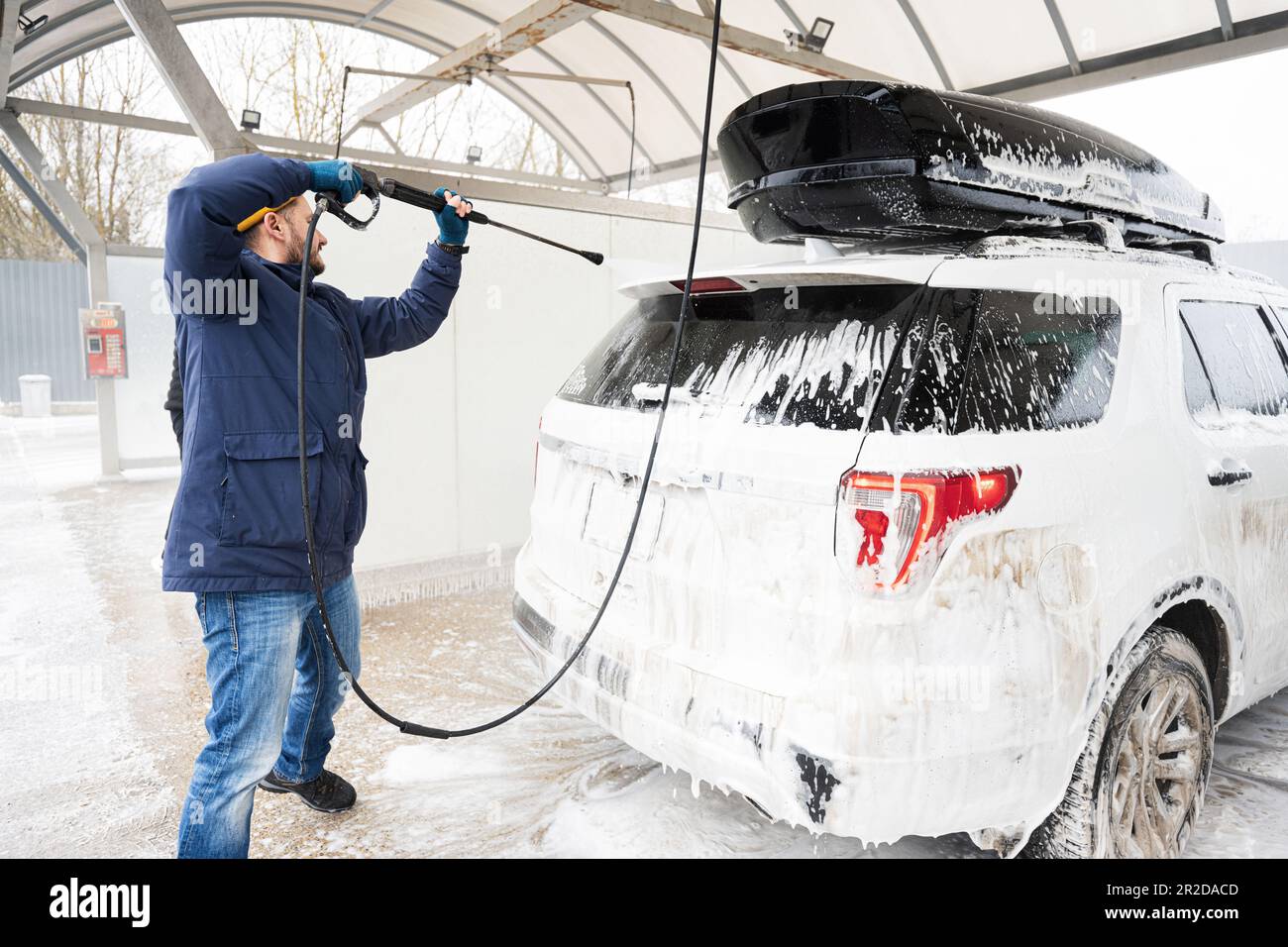 Man washing high pressure water american SUV car with roof rack at self ...