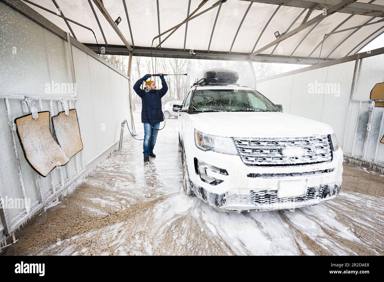 Man washing high pressure water american SUV car with roof rack at self ...