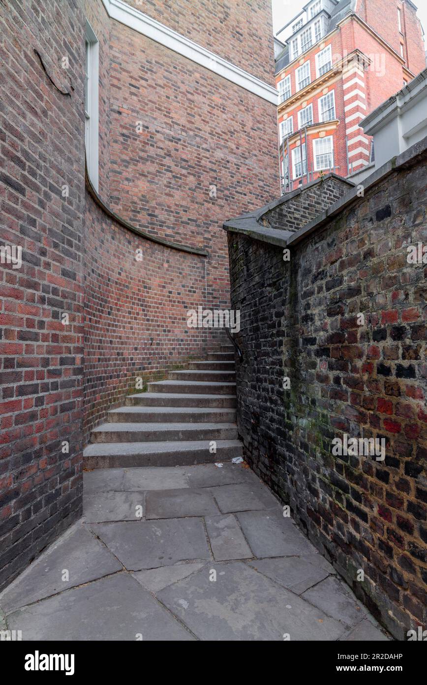 A mysterious and hidden old back alley with staircase in London at ...