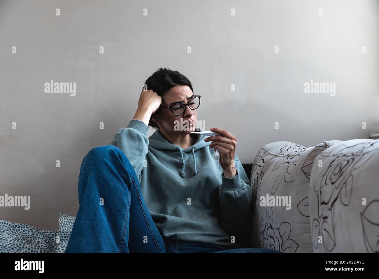 Ill Upset Young Woman Sitting On Sofa Covered With Blanket Freezing
