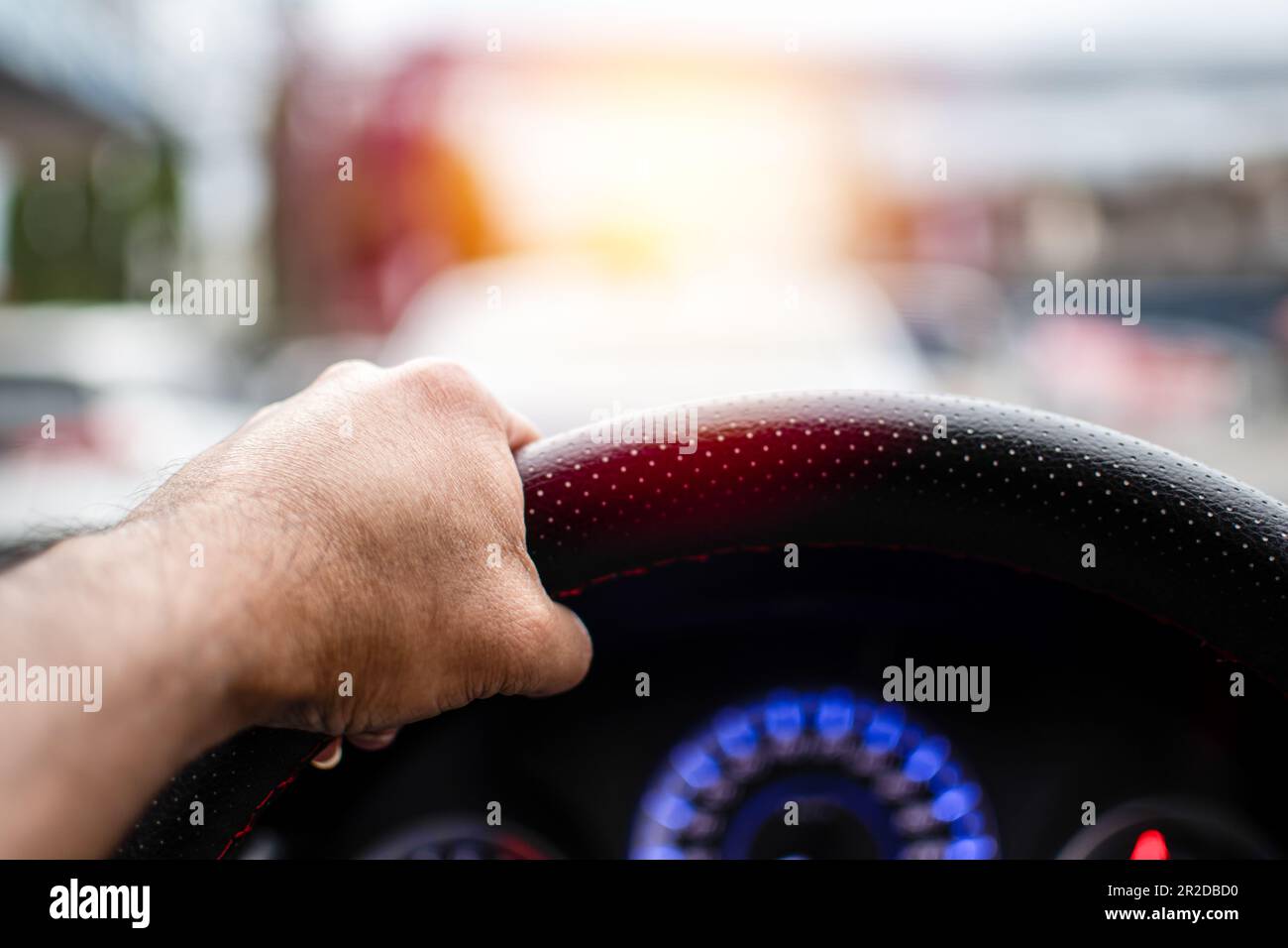 A man driving a left hand to hold the steering wheel To control the car ...