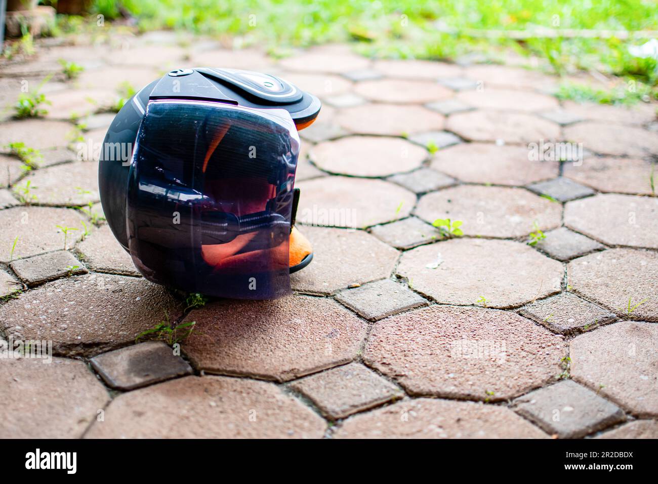 Black motorcycle helmet lies at an angle on the roadway from an ...