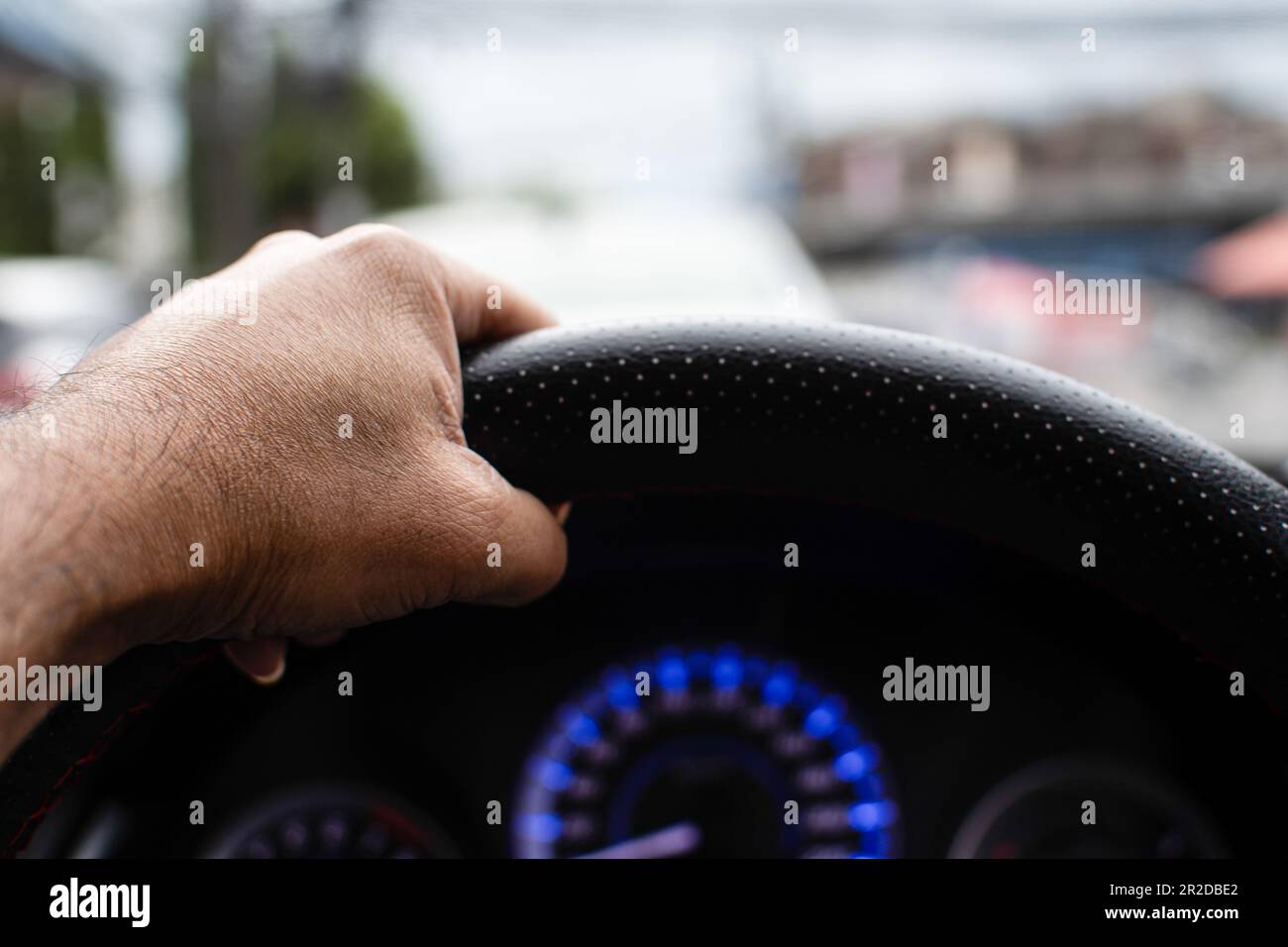 A man driving a left hand to hold the steering wheel To control the car ...