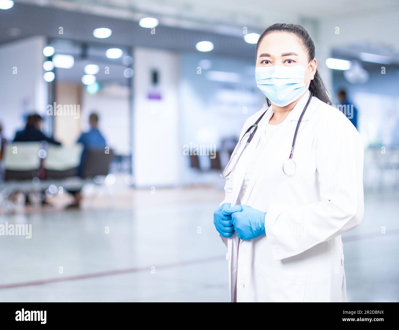 Woman doctor stands in front of an examination room in a hospital ...