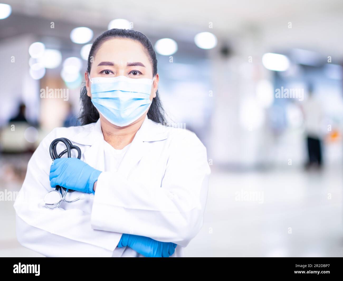 Woman doctor stands in front of an examination room in a hospital ...