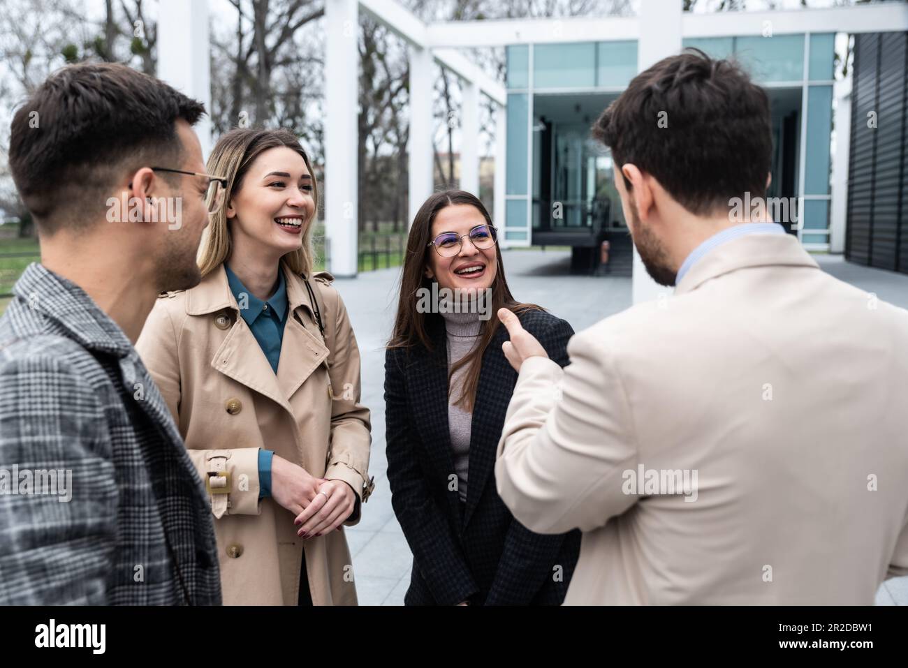 Young businesspeople standing in front of office building talking ...