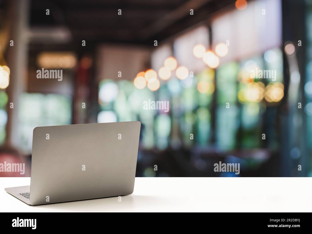 The back of the laptop is blank, placed on a white desk, and nobody, no ...