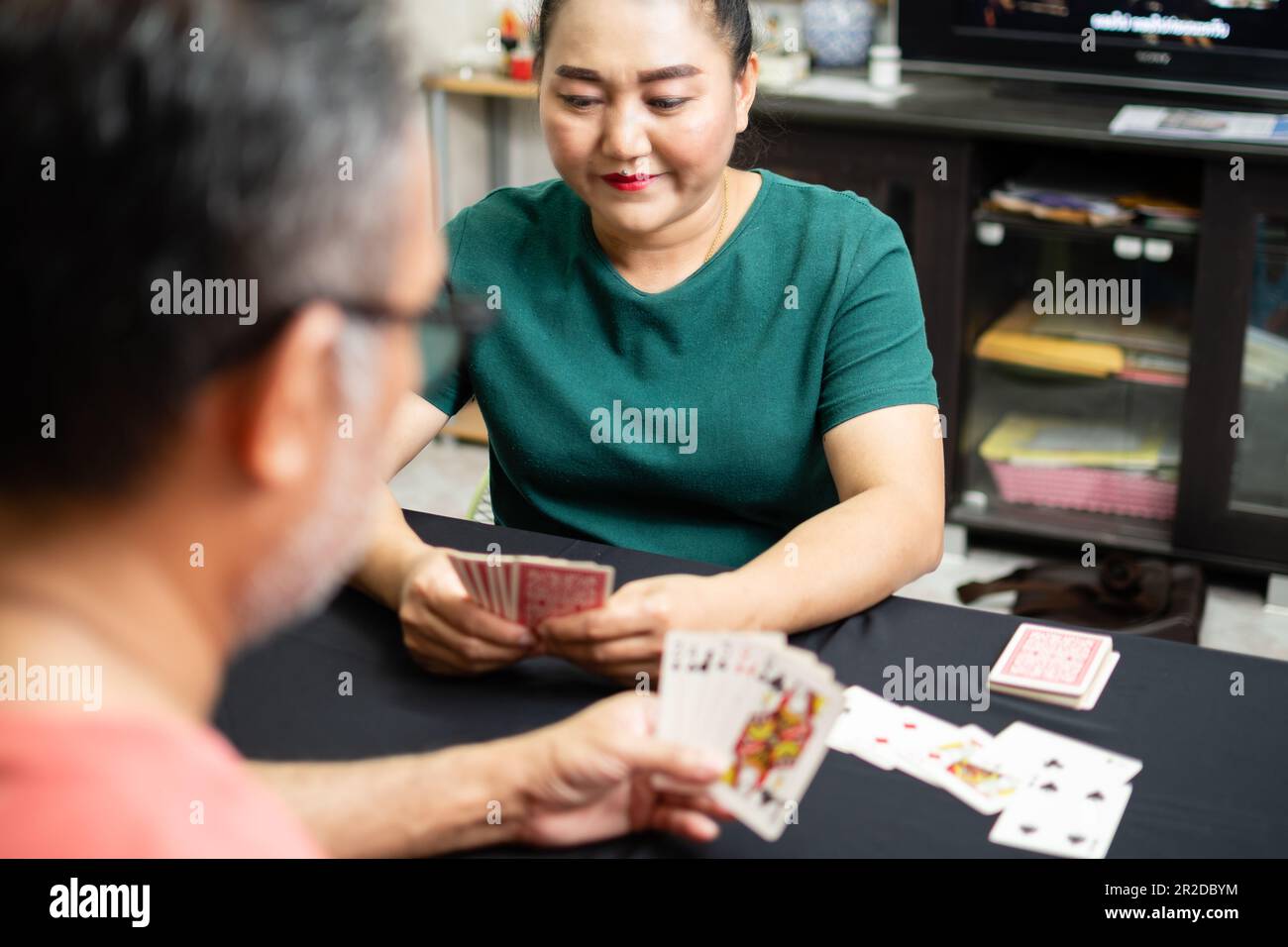 Couples playing cards at home for date night inside. They both held ...