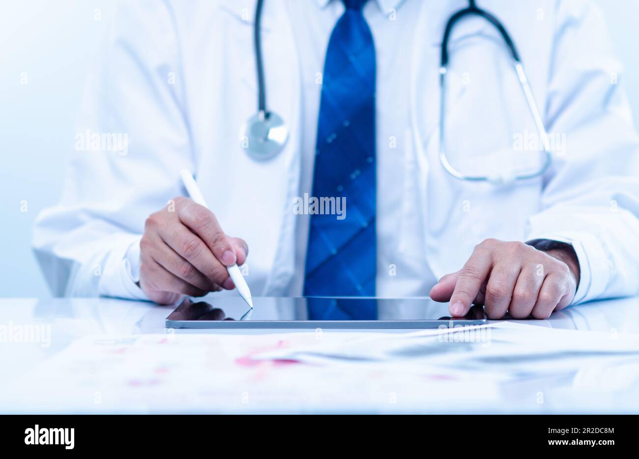 professional doctor man wearing a uniform using a device tablet of ...