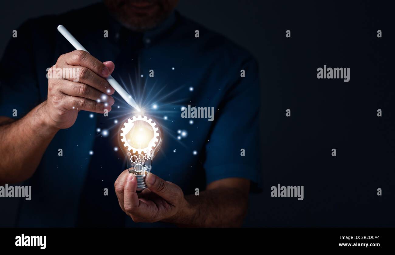 Businessman holding illuminated light bulb. Inspiration of ideas for ...