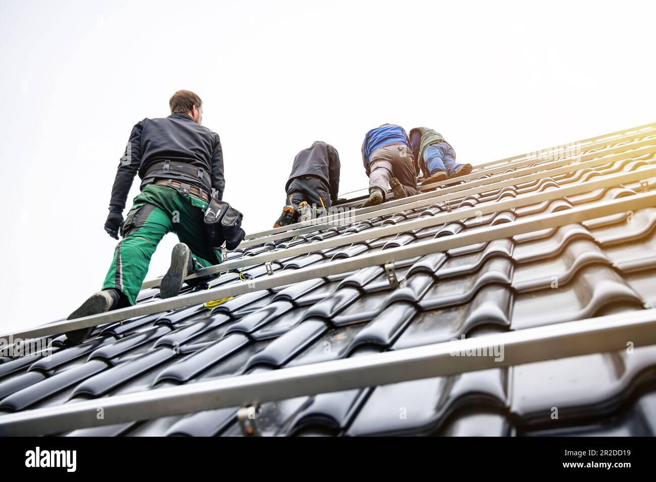 Workers an a roof of a house installing solar panels Stock Photo - Alamy
