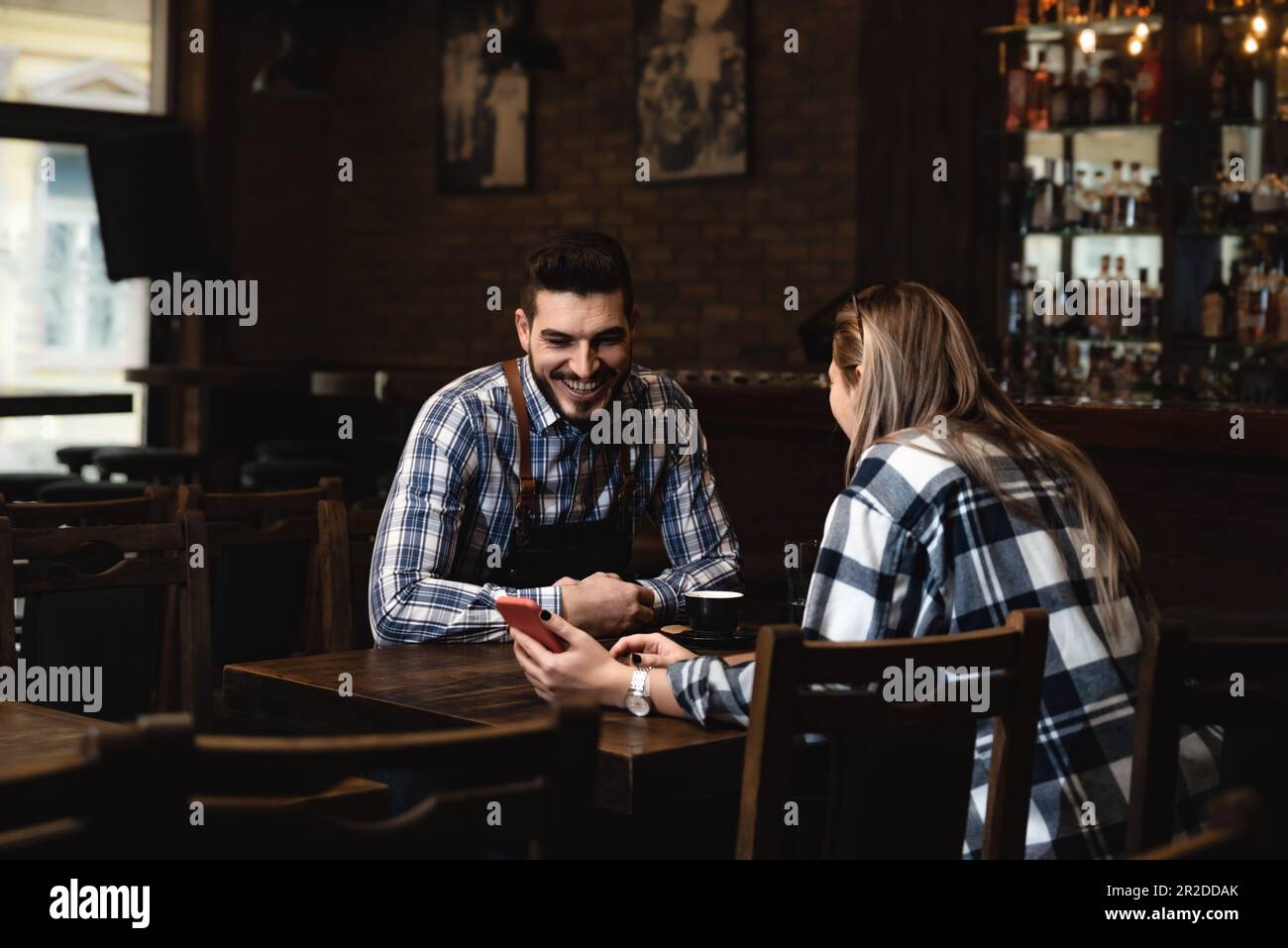 Young colleagues bartenders and waitress sit at the bar and get bored ...
