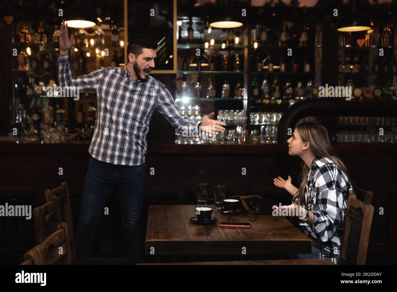 Young waiter resigns and leaves his job in a bar because of an argument ...