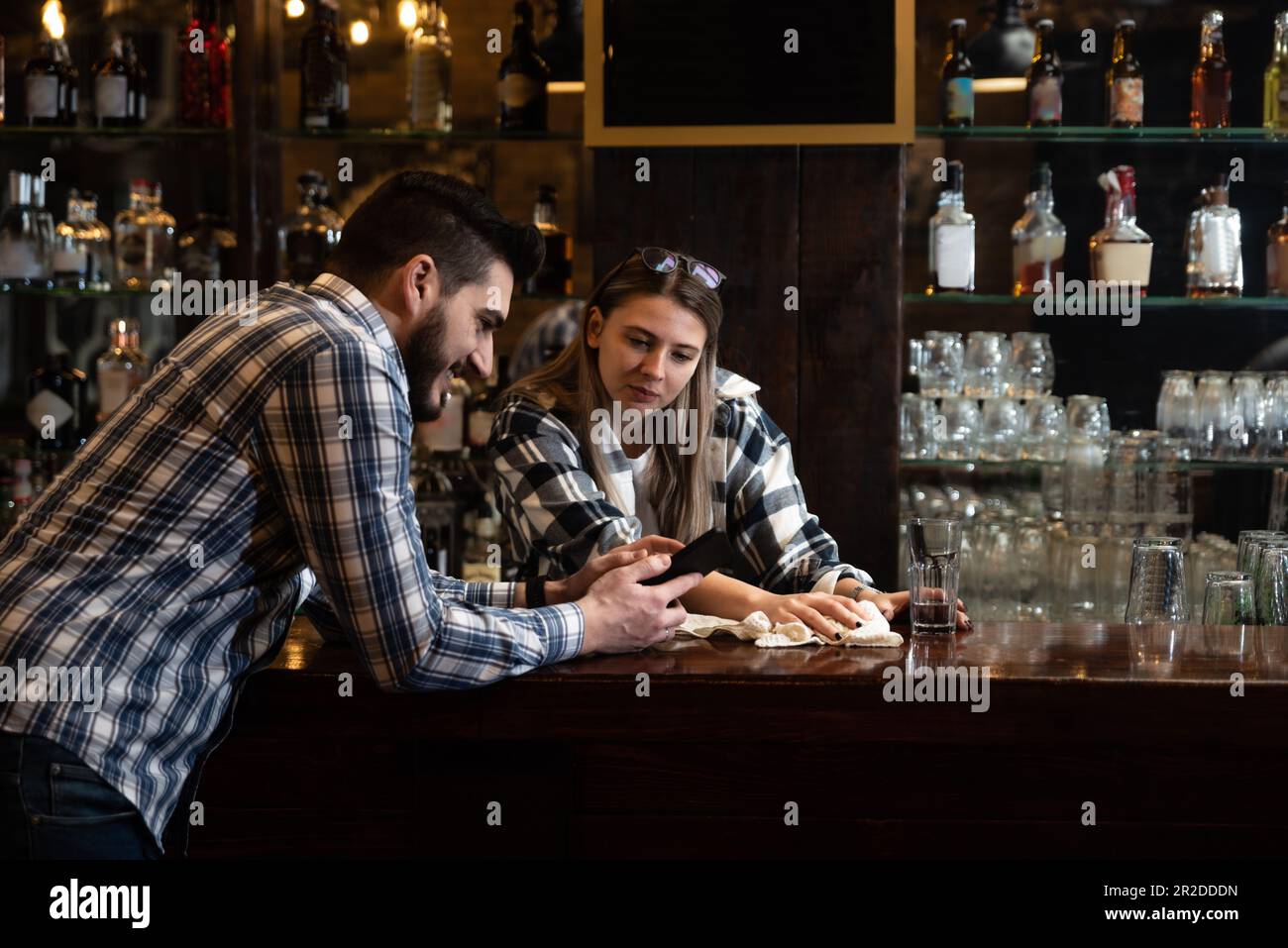 Young colleagues bartenders and waitress sit at the bar and get bored ...