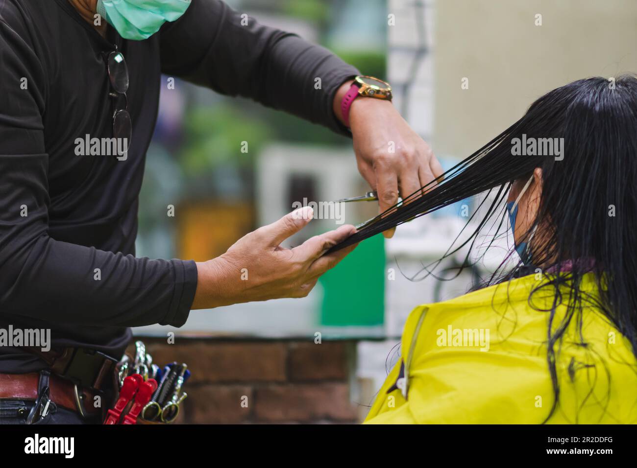 professional man hairdresser wearing face mask holding scissors and ...