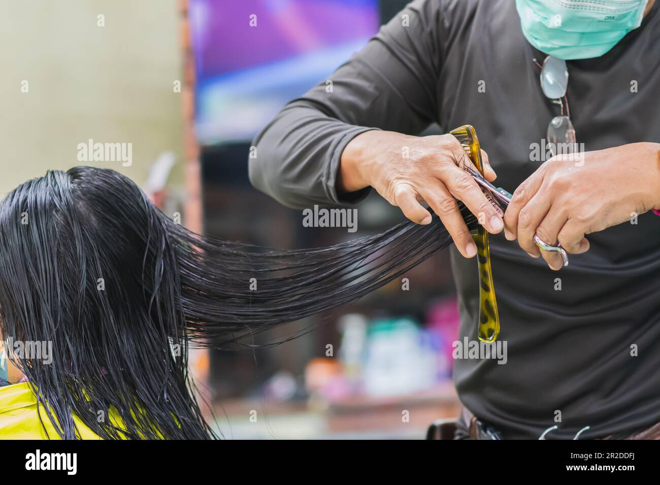 professional man hairdresser wearing face mask holding scissors and ...