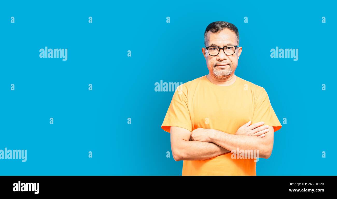 A man stood with his arms crossed. Wear an orange shirt and look at the ...