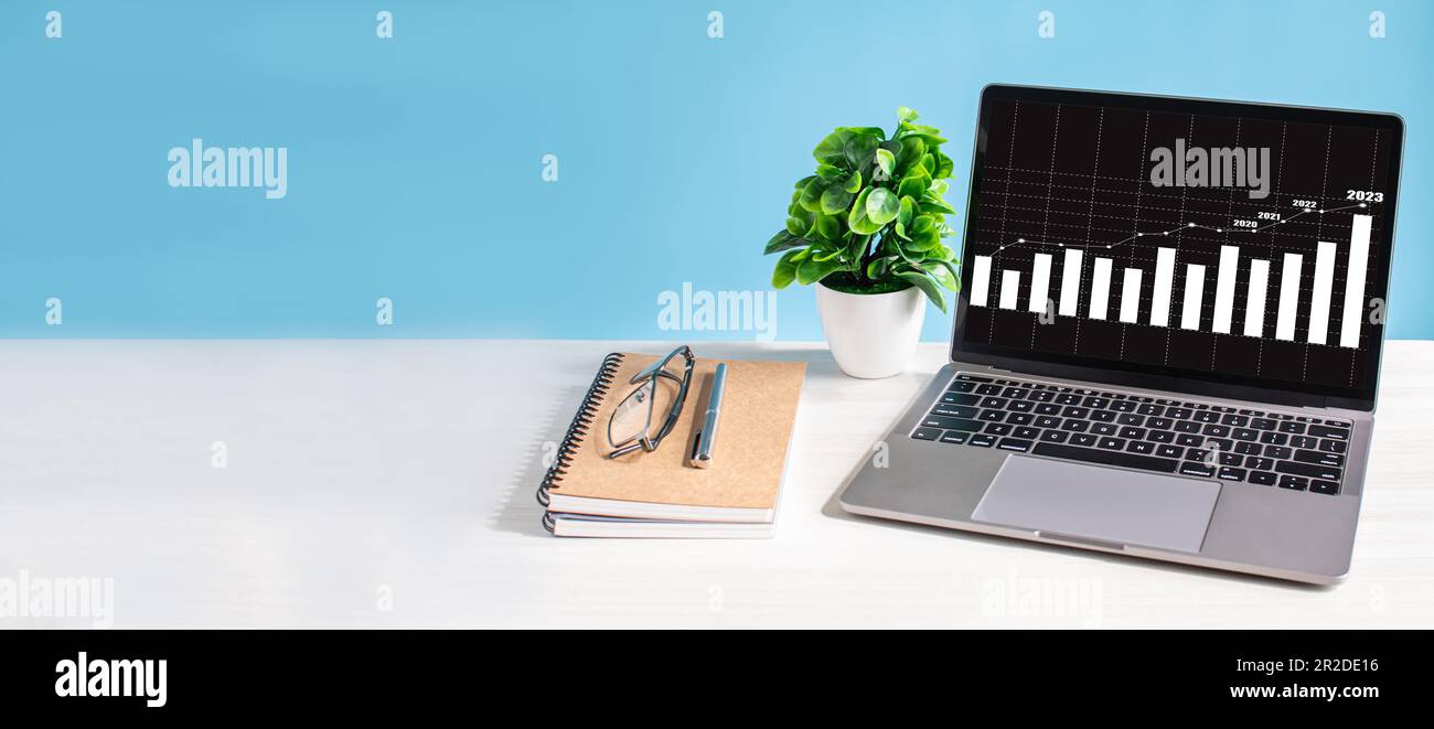 Laptop screen shows a graph of the 2023 economy rising and is placed on ...