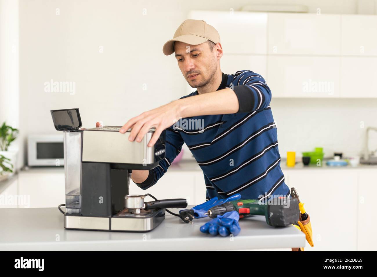 professional young worker fixing coffee machine Stock Photo - Alamy