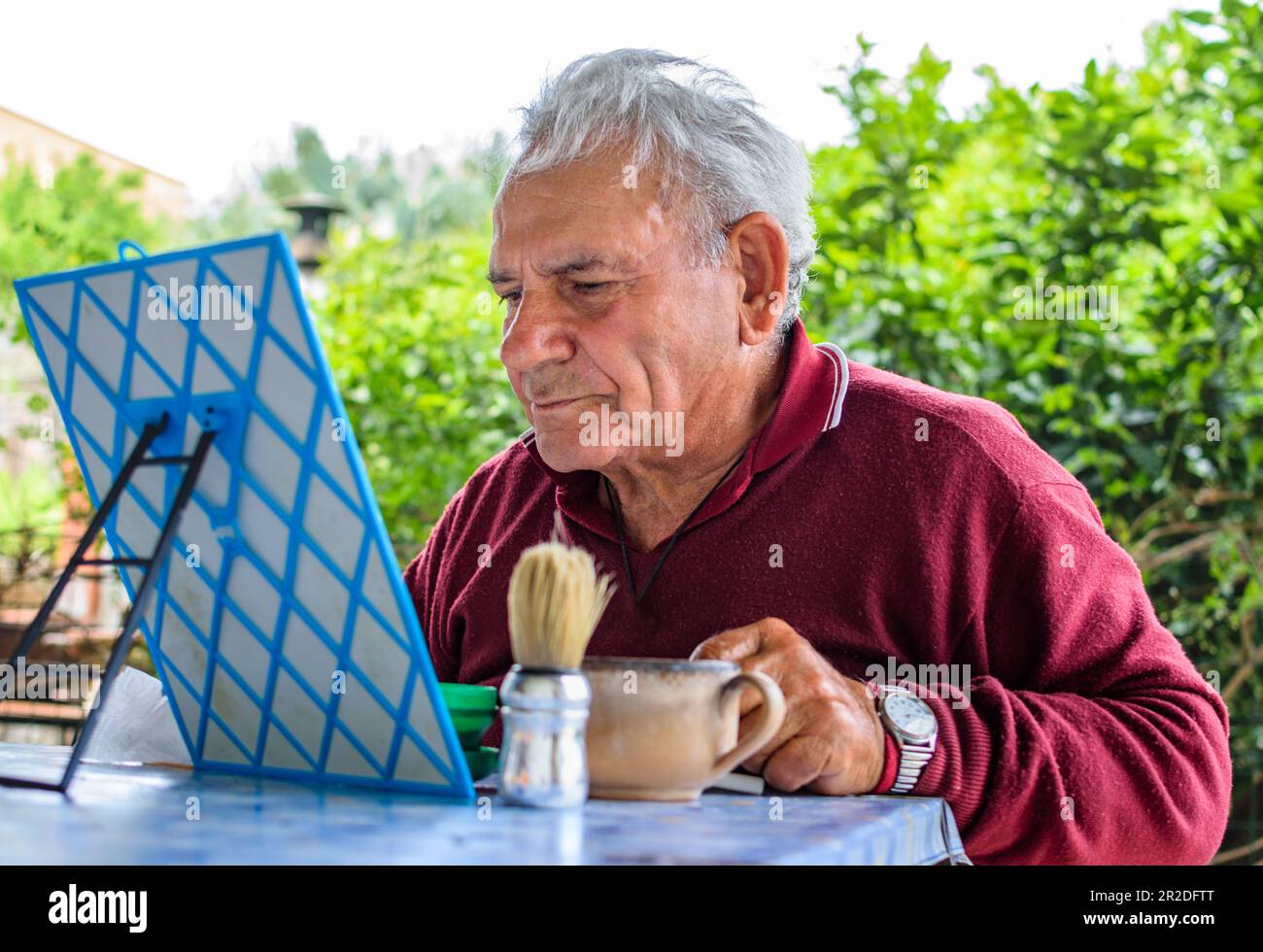Old man with gray hair watching his face on mirror before shaving Stock ...