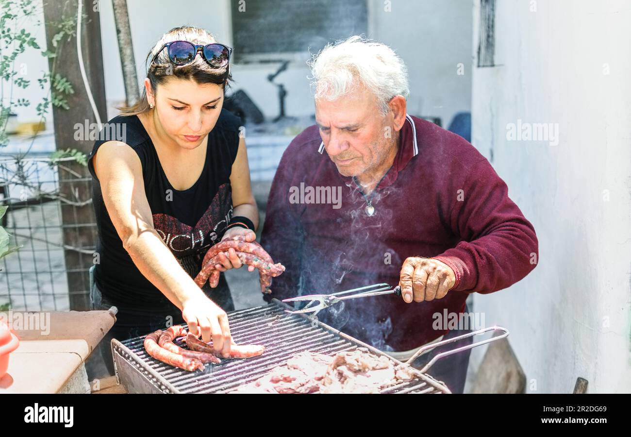 Grandfather cooking on barbecue with his granddaughter Stock Photo - Alamy