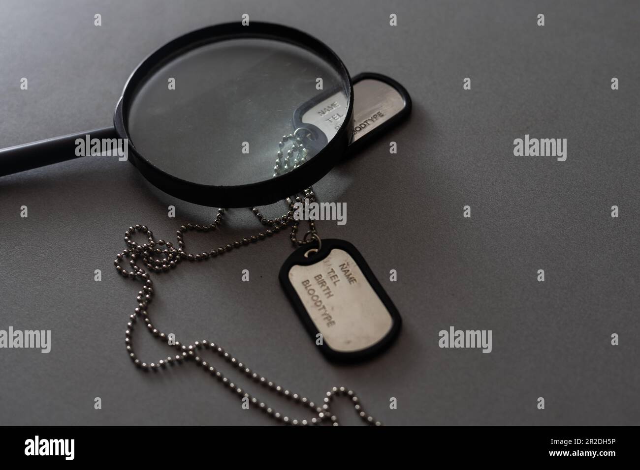 Military ID tags magnifying glass Stock Photo - Alamy