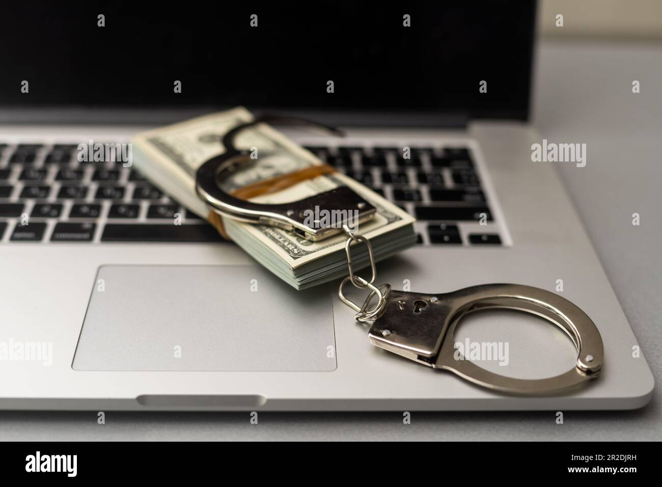Cyber crime legal law police handcuffs on a hundred dollar bills with ...