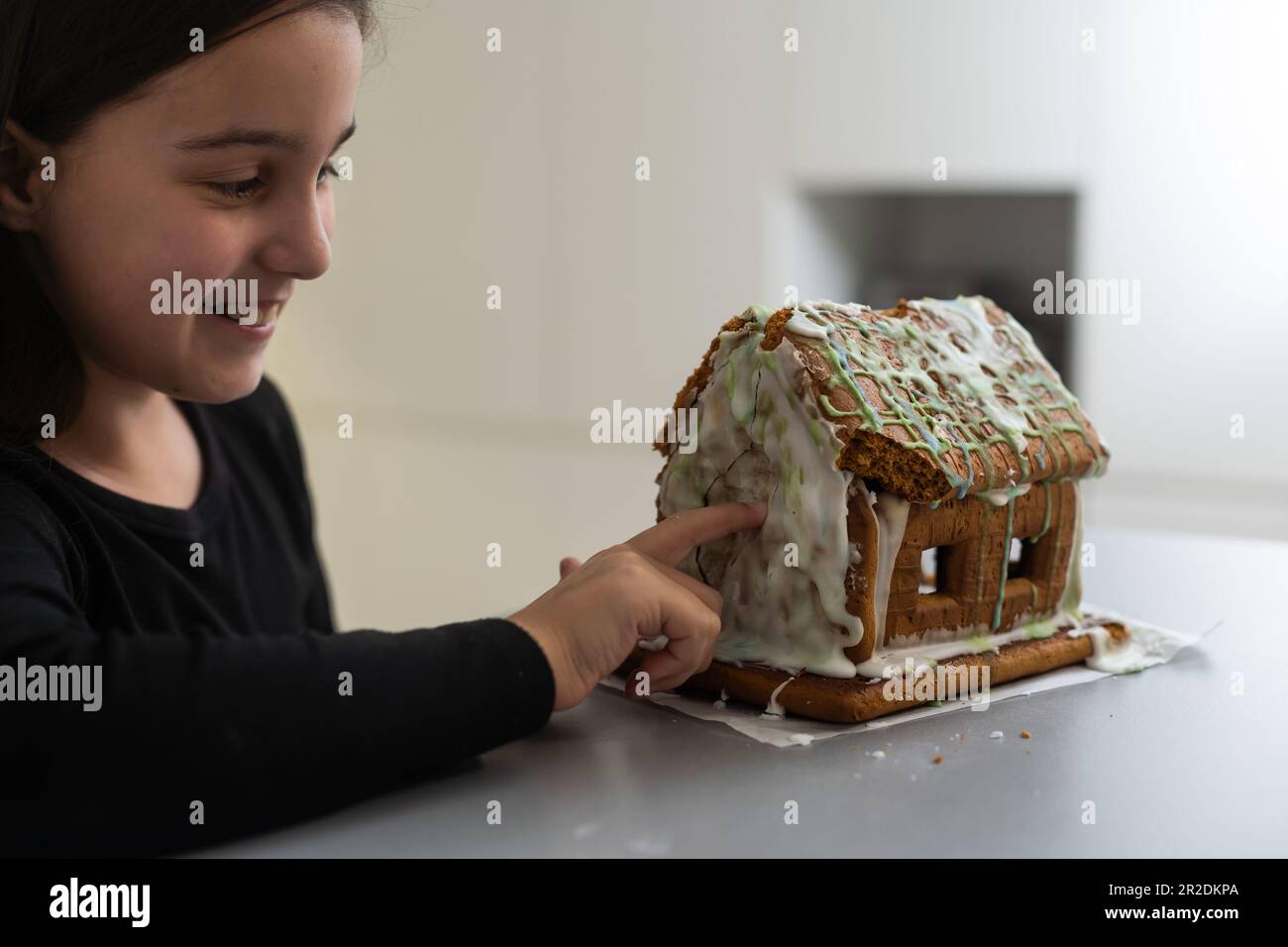 A teenage girl is eating a gingerbread house Stock Photo - Alamy