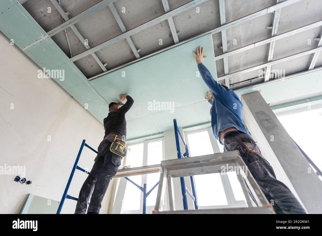 Drywall Installers. Men holding a gypsum board figured cut Stock Photo ...