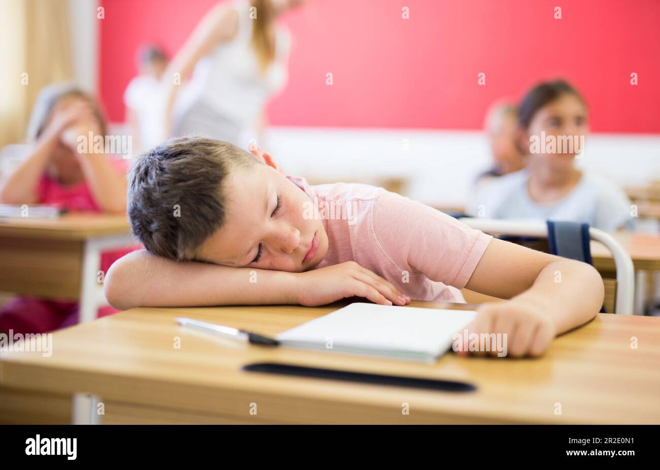 Tired school boy sleeping in classroom during lesson Stock Photo - Alamy