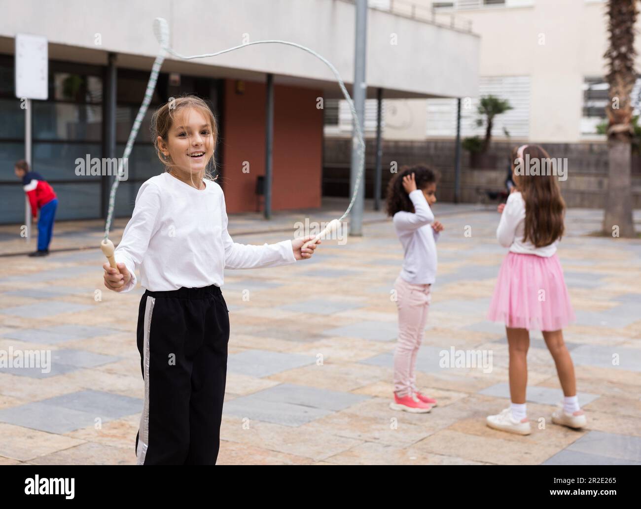 Sporty tween girl jumping rope in school yard during recess Stock Photo ...