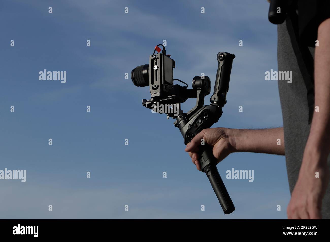 anonymous man using a gymbal over blue sky Stock Photo - Alamy